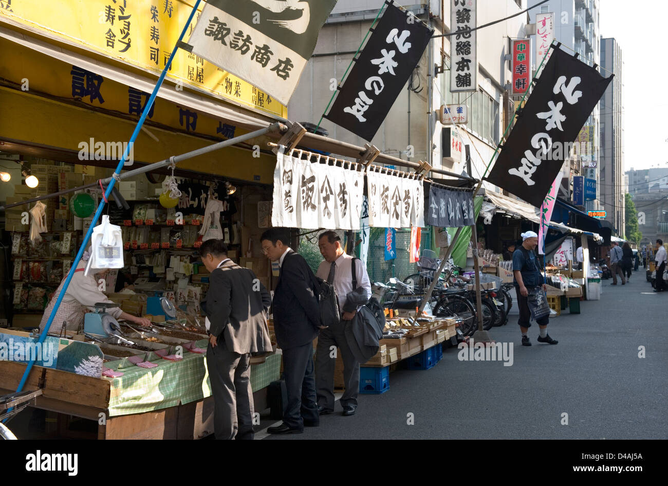 Early morning street scene of retail shops busy with workers and buyers ...