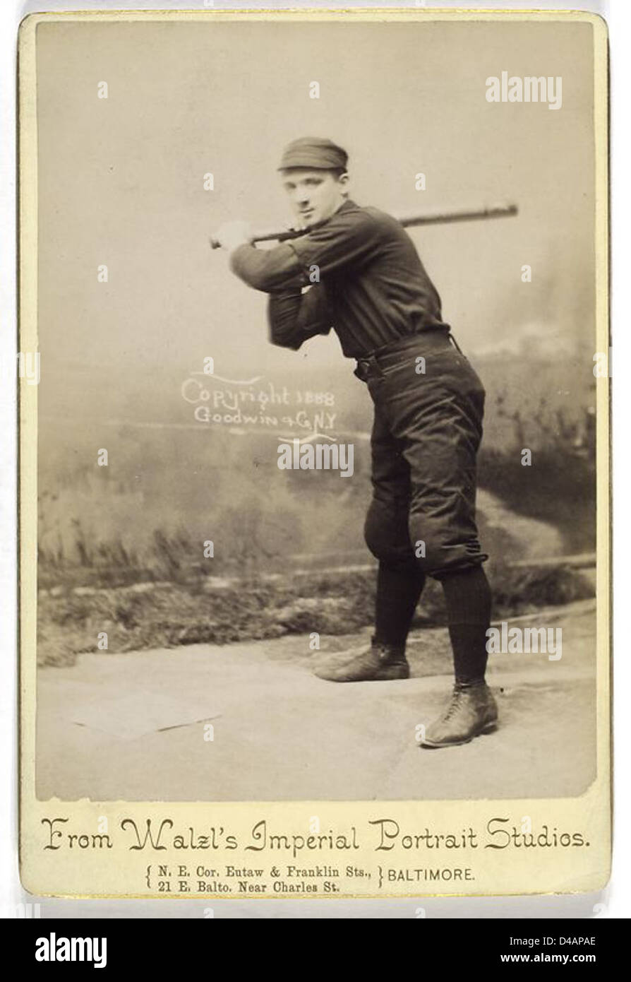 An unidentified baseball player, wearing a dark uniform, is captured in ...