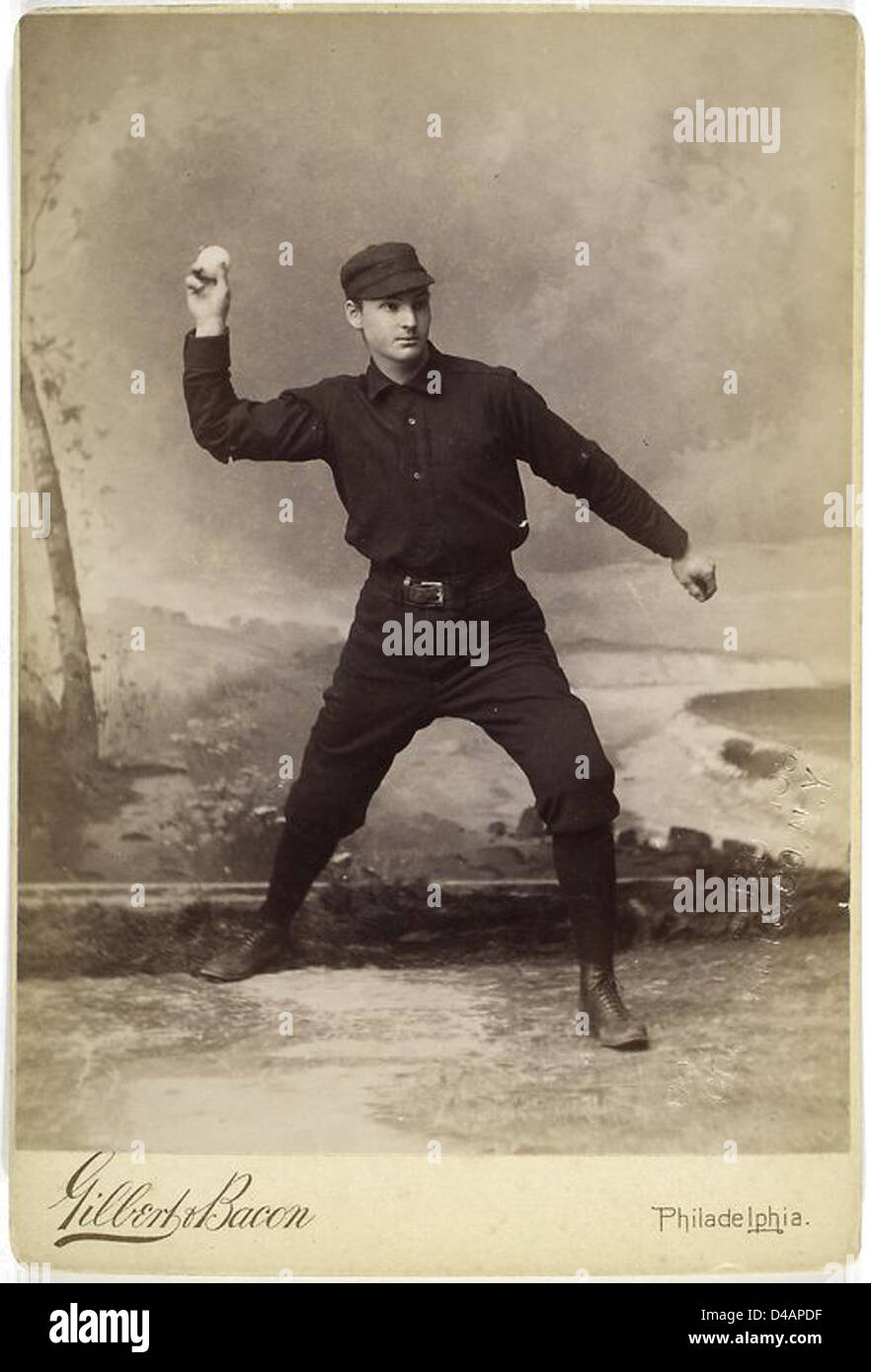 This photograph features an unidentified baseball player wearing a dark ...