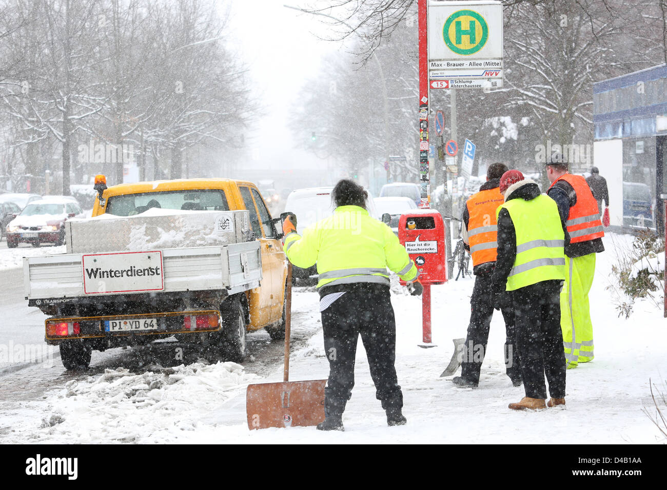 Employees of the winter service clear a bus stration from snowe and ice ...