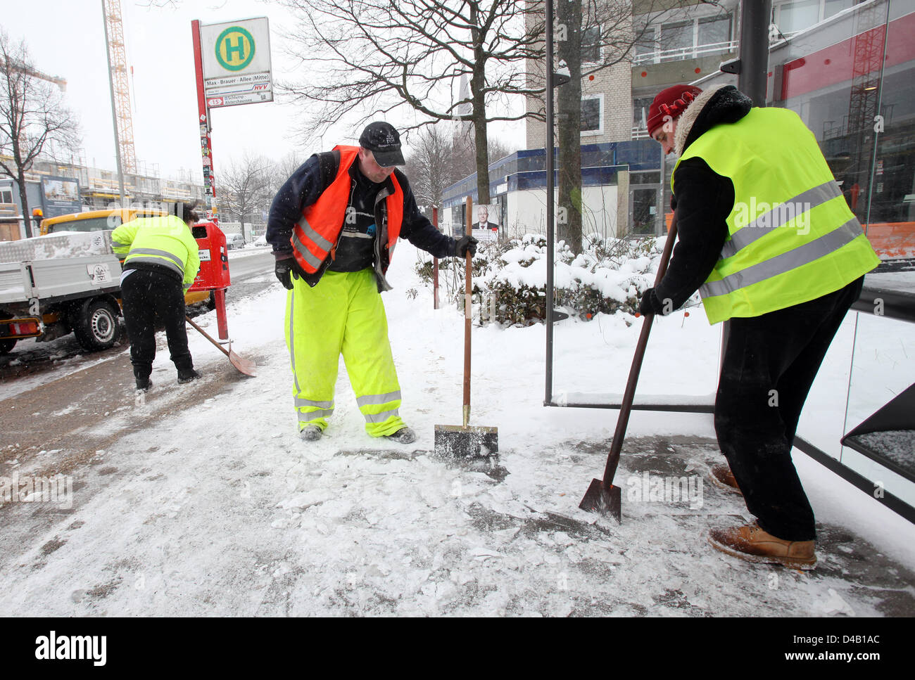 Employees of the winter service clear a bus stration from snowe and ice ...