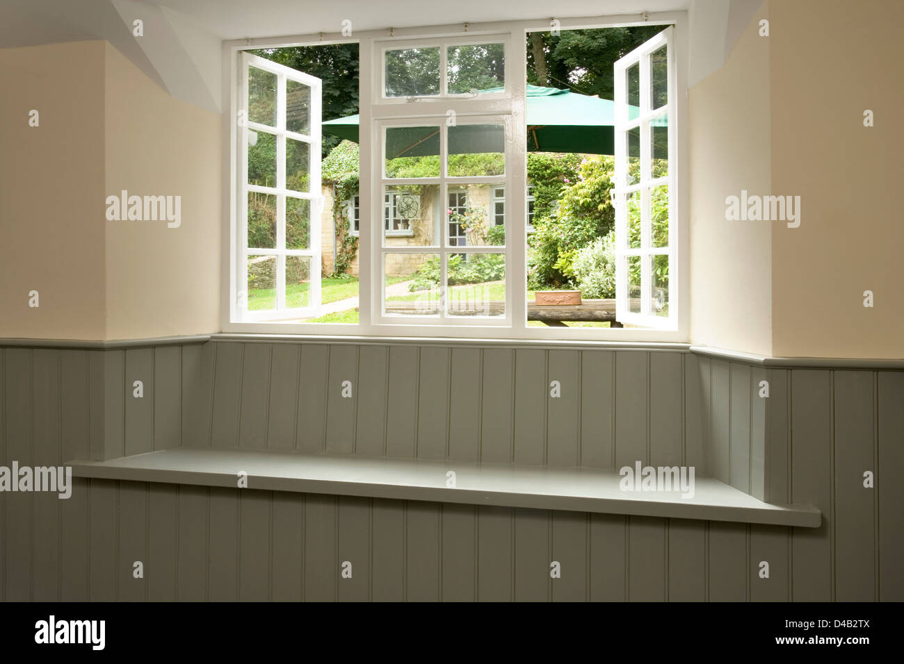 A new painted wood panelled window seat with a garden view Stock Photo ...