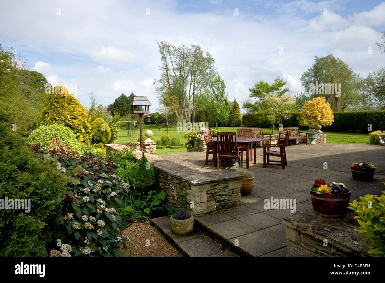 UK gardens. A large mature lawned garden with trees, shrubs and a patio ...