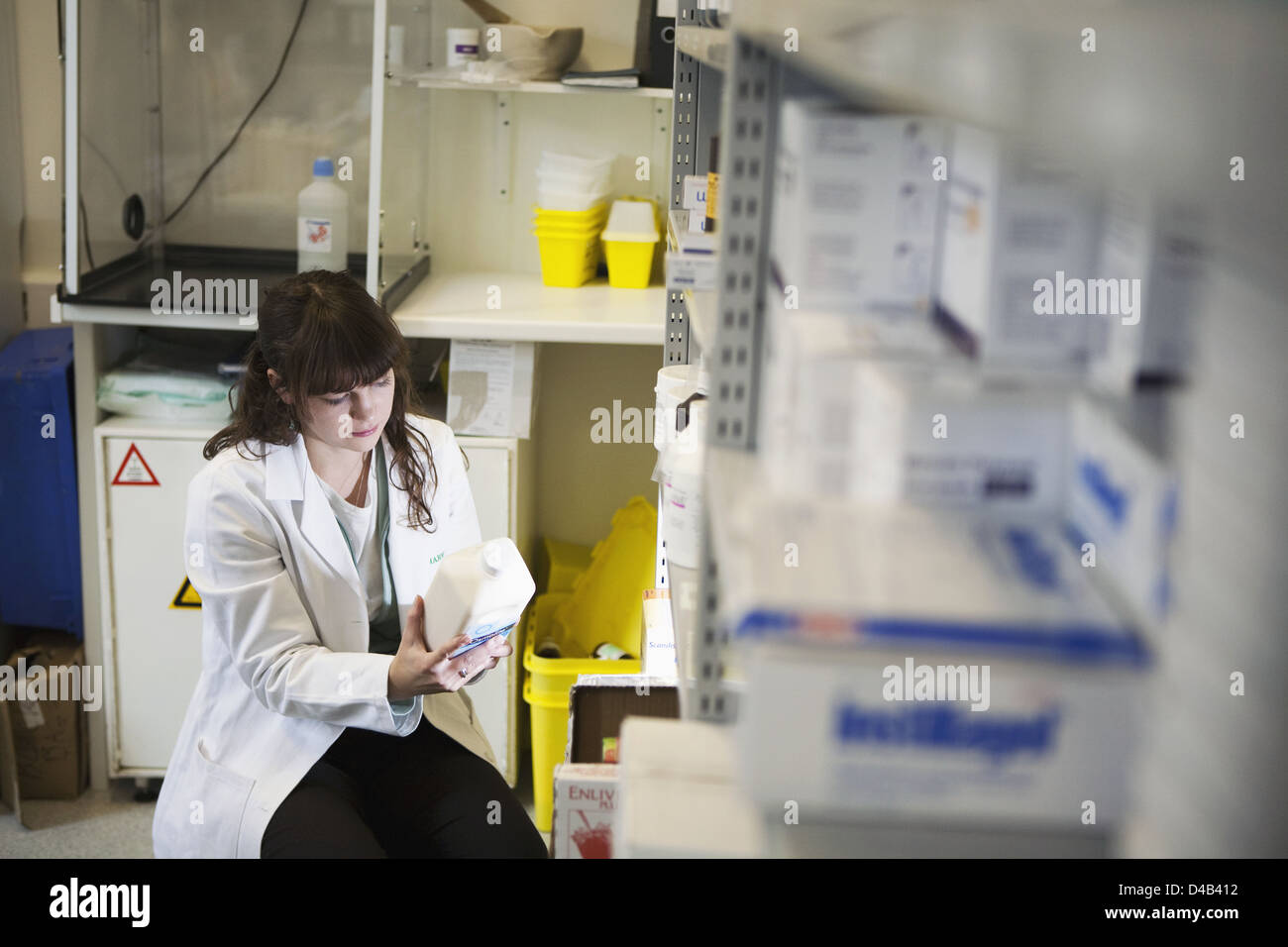 Female pharmacist reading label on medicine bottle Stock Photo - Alamy