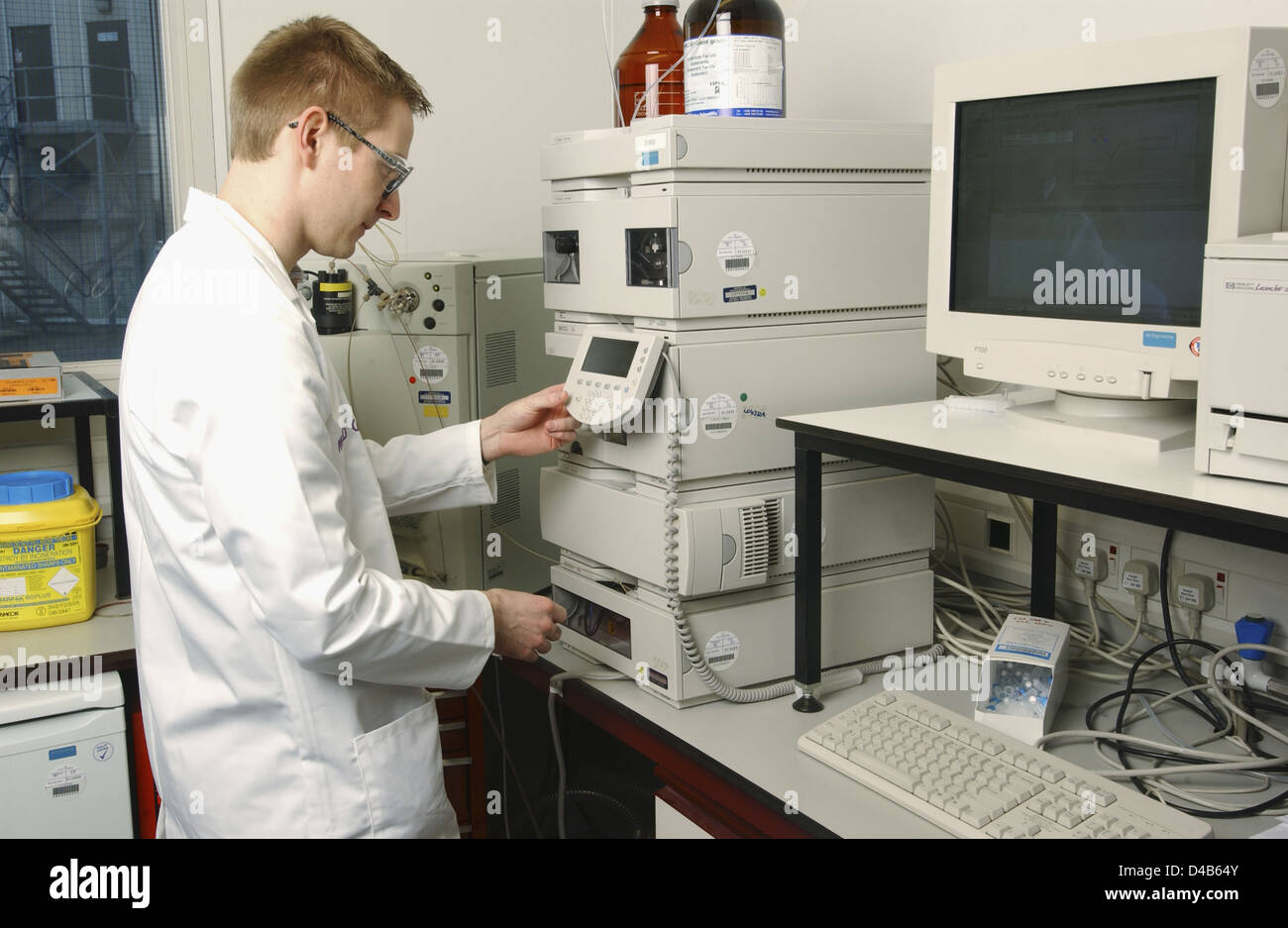 Laboratory assistant analyzing computer readout Stock Photo - Alamy