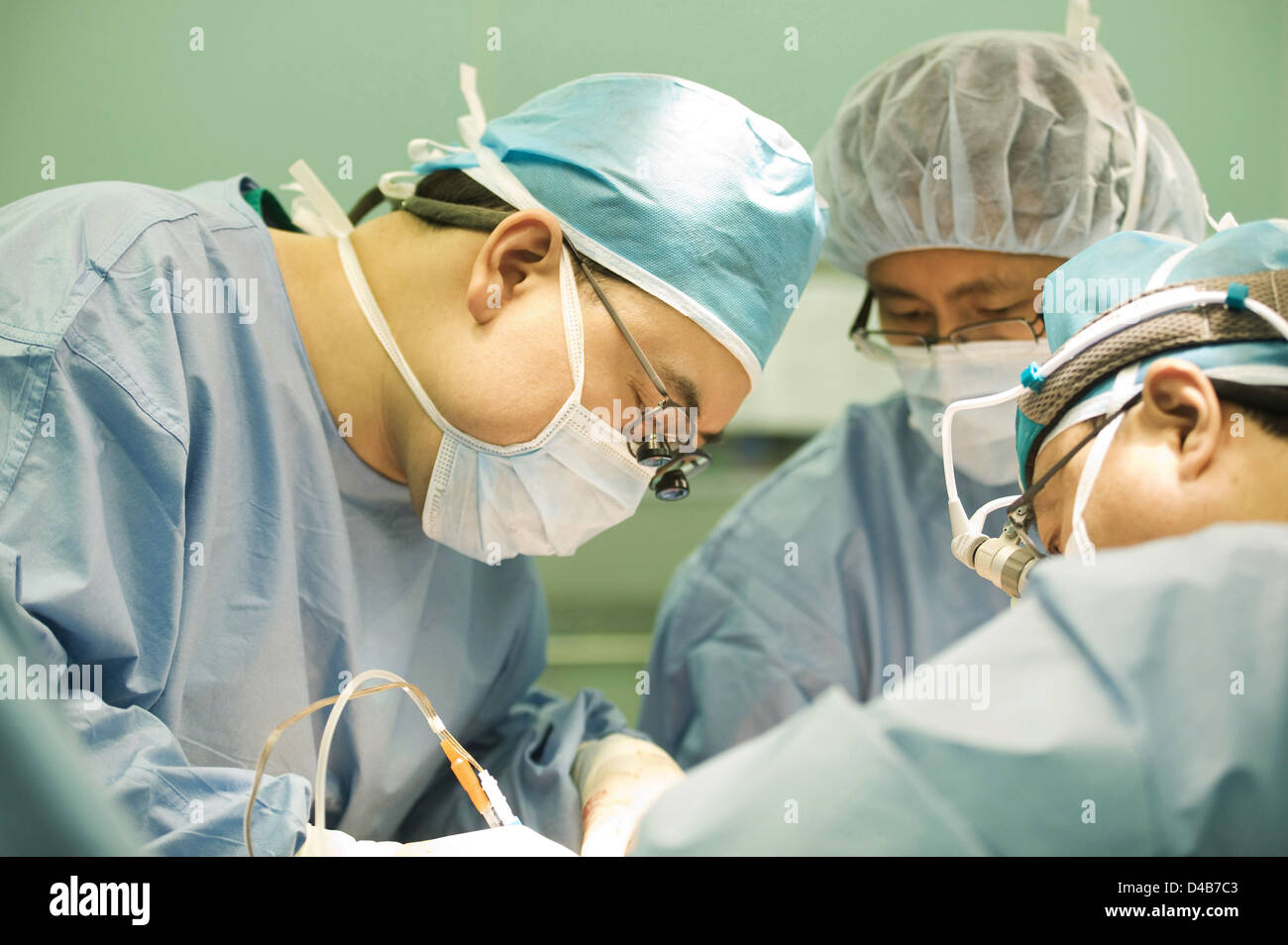 Surgeons operating on patient Stock Photo - Alamy