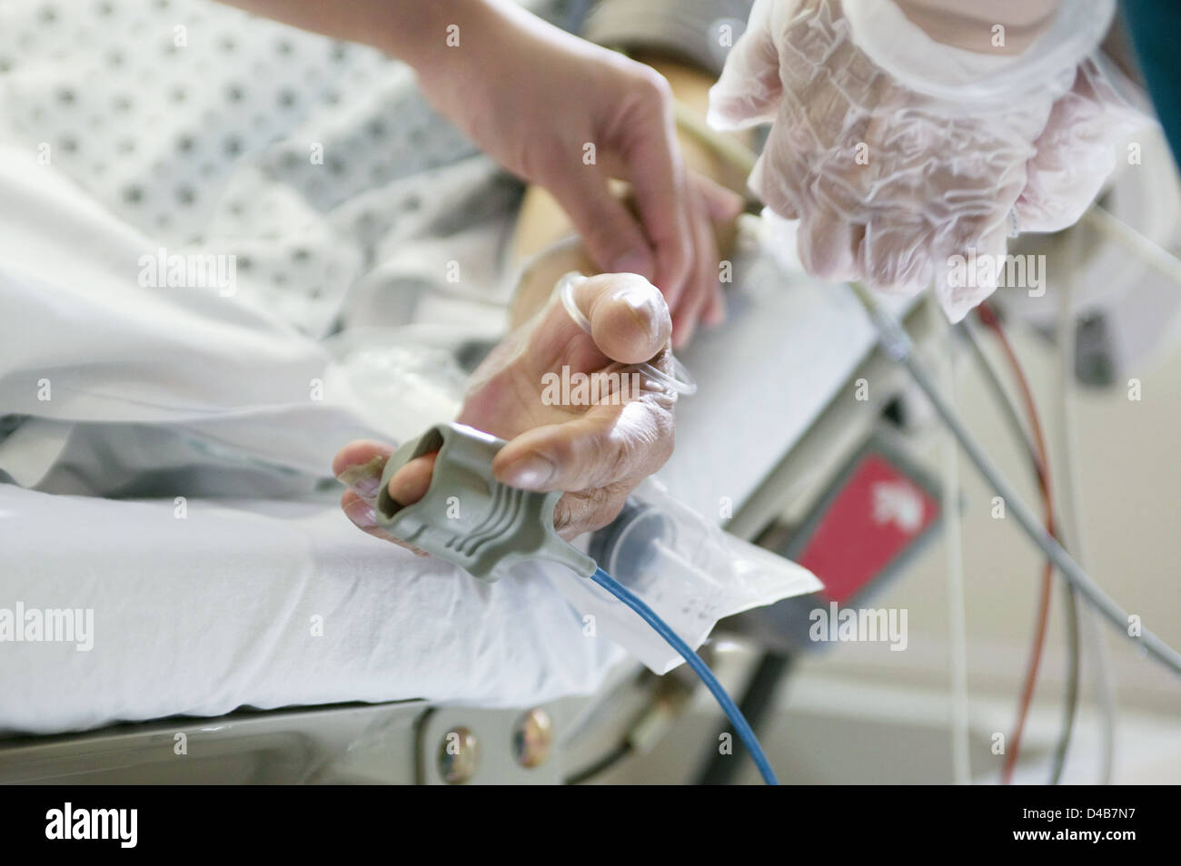 A nurse attaching oximeter (blood oxygen meter), used to measure the ...
