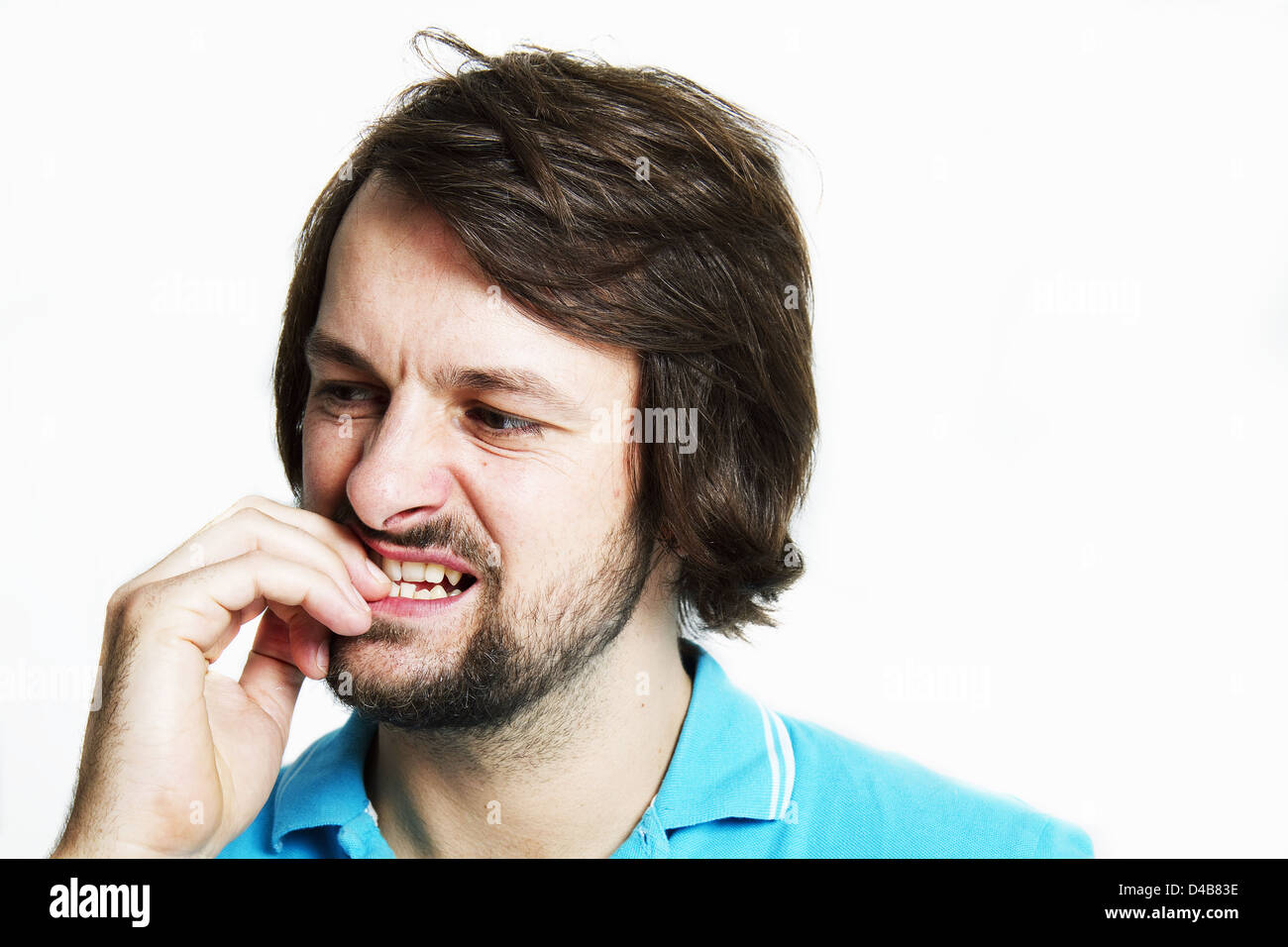 Young man biting his nails Stock Photo - Alamy