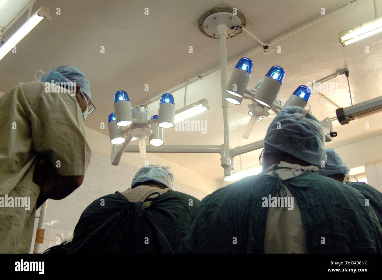 Operating staff looking over surgical procedure in operating theatre ...