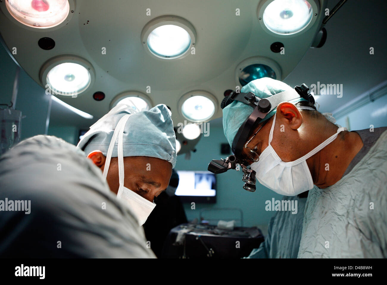 The lead surgeon wears magnifying lenses over glasses magnifying lenses ...