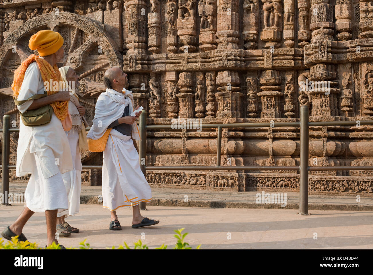 A group of Krishna disciples admire a façade of the Konark Sun Temple ...