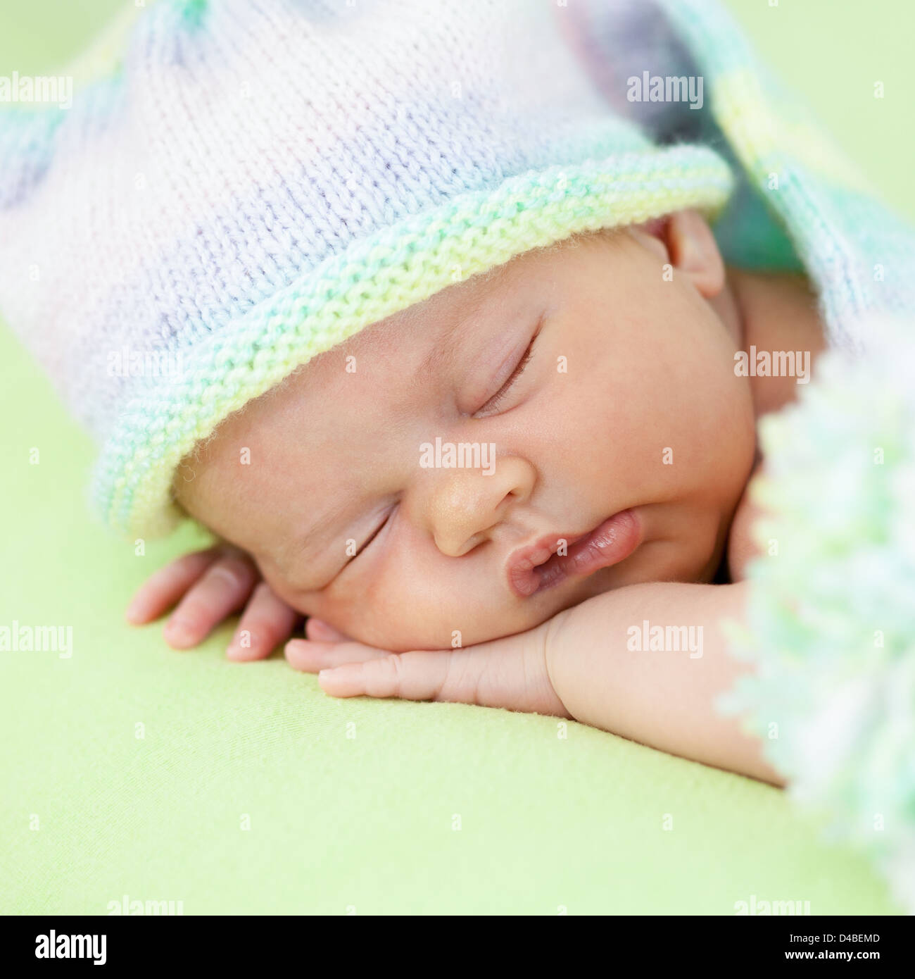 adorable baby weared cap sleeping on green Stock Photo - Alamy