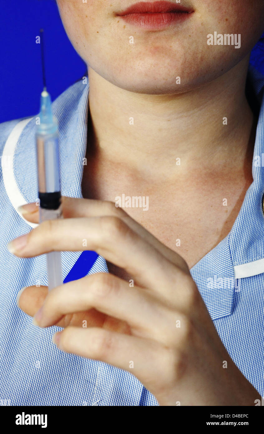 Young female nurse holding hypodermic syringe hi-res stock photography ...