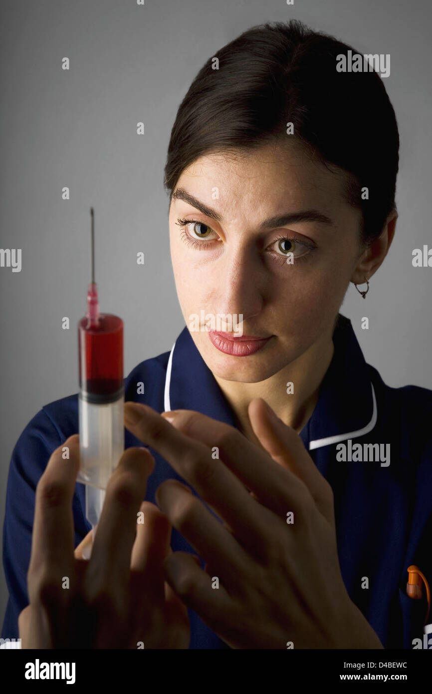 The nurse checking any trapped air that could be in solution It ...