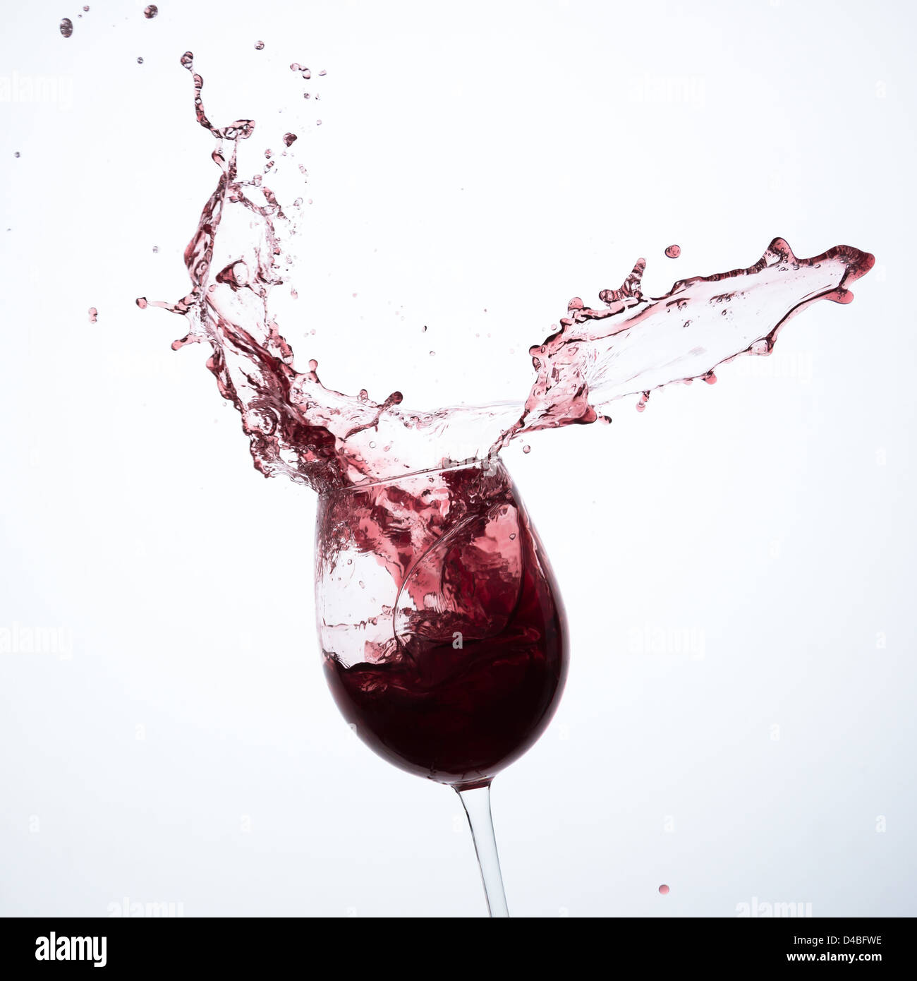 red wine splashing out of a glass, isolated on white Stock Photo - Alamy
