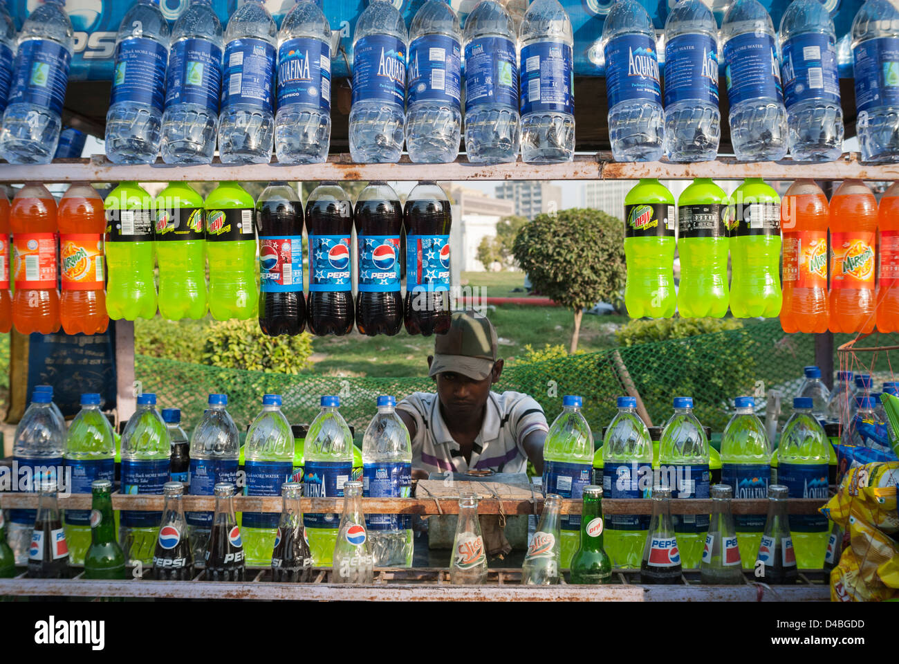 A young India man keeps a close eye on his market stall selling soft ...