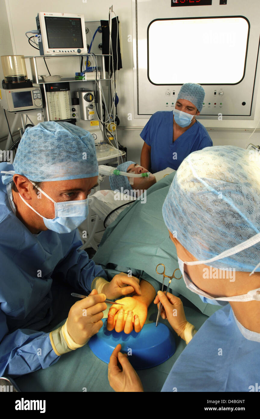 Surgeon, nurse and anesthetist operating on patient with hand disorder ...