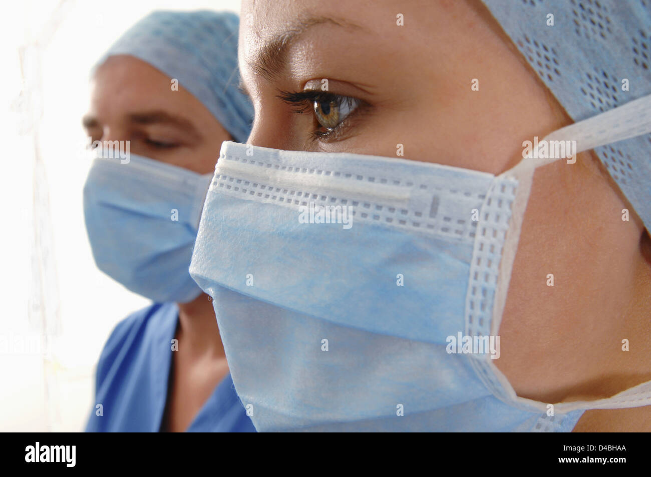 Close up of male doctor and female nurse wearing blue surgical caps ...