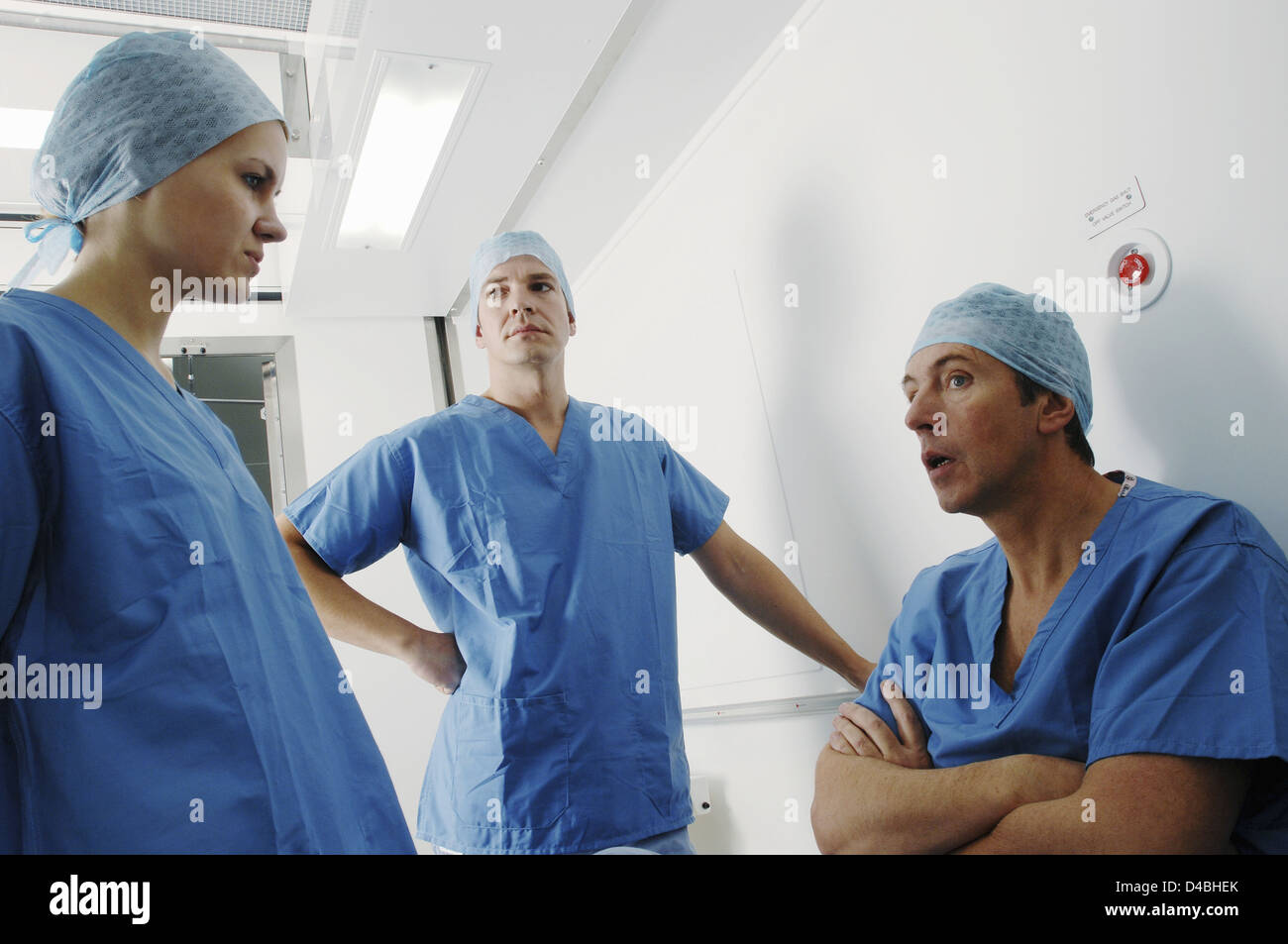 Three surgeons relaxing in hospital corridor Stock Photo - Alamy