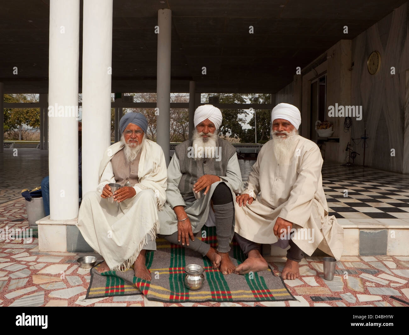 Three traditionally dressed Sikh elders seated at the gurdwara at ...