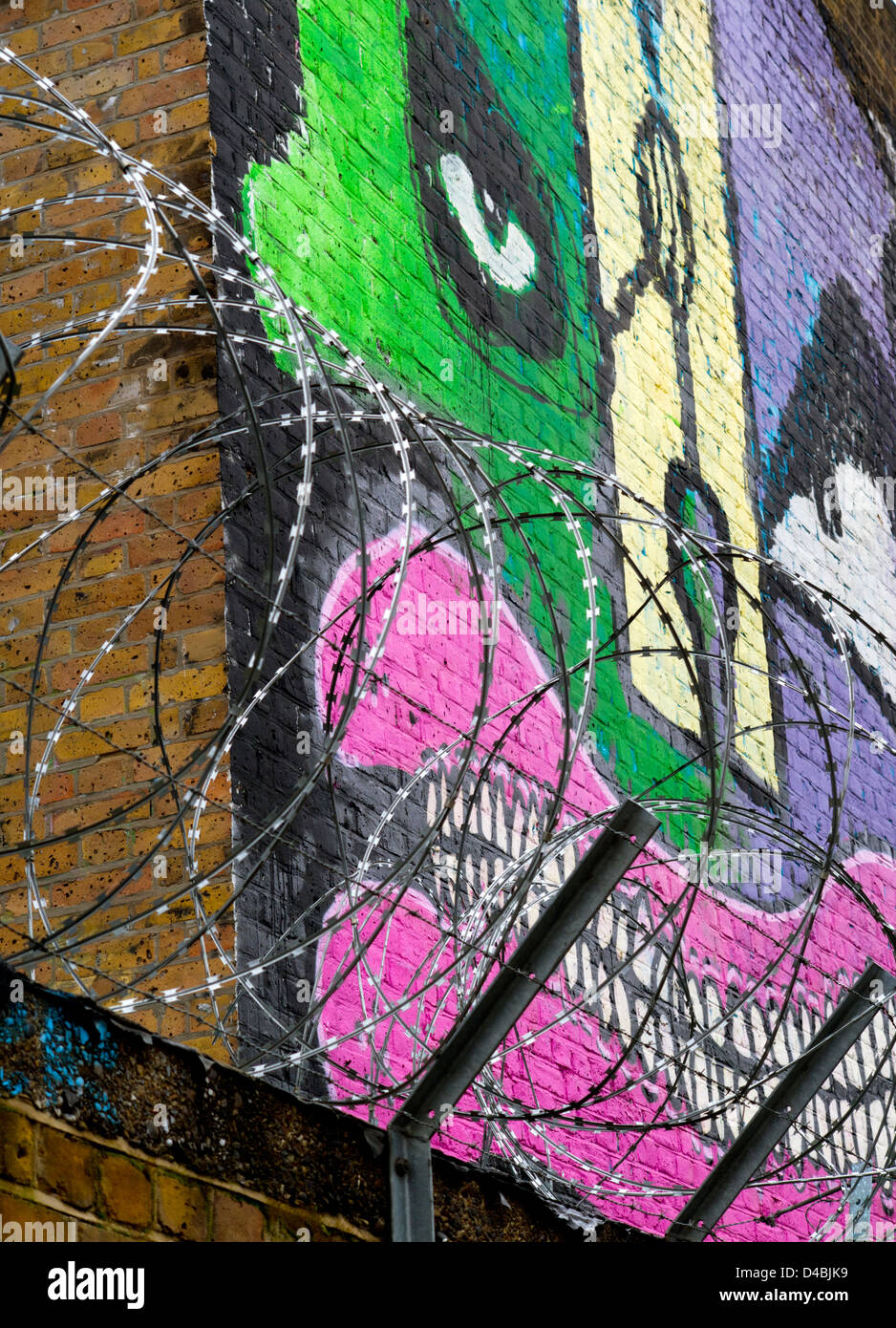 Graffiti and razor-wire along the River Lee by the London Olympic park ...