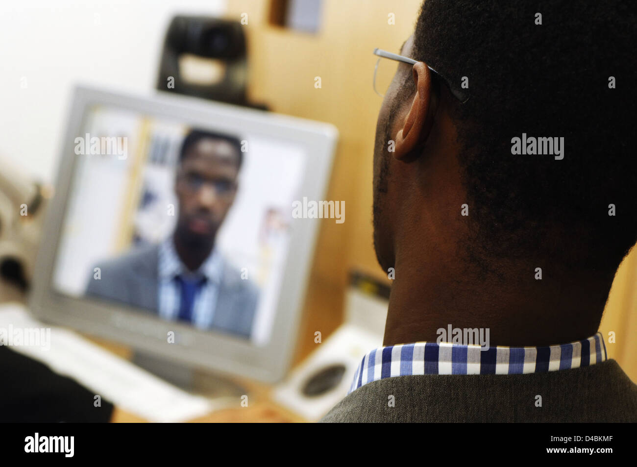 Man trying on new set of frames using computer to see how they look ...