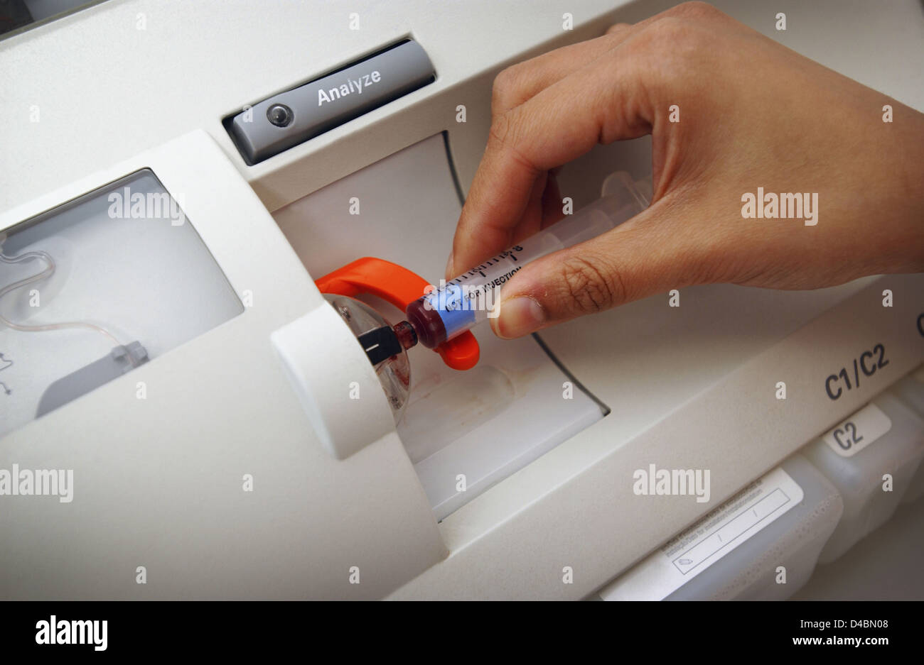 Laboratory technician in using a machine to analyze and wash blood ...