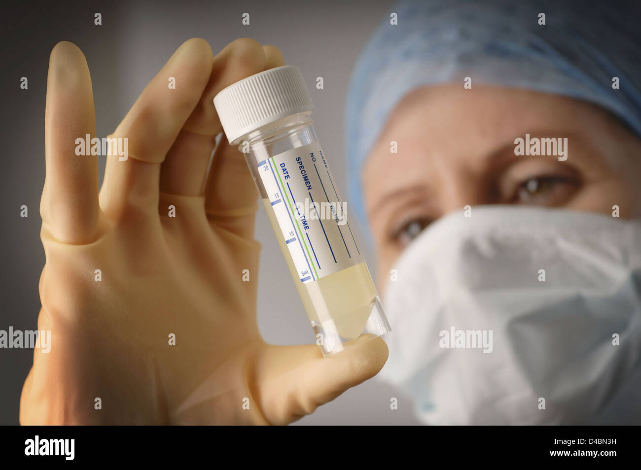 Hospital worker holding specimen tube 3/4 full of liquid Stock Photo ...