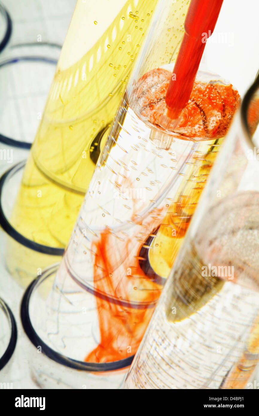 Pipetting red liquid into clear liquid solution Stock Photo - Alamy
