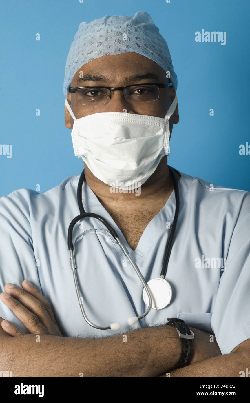 Portrait of surgeon wearing surgical mask, with stethoscope around his ...