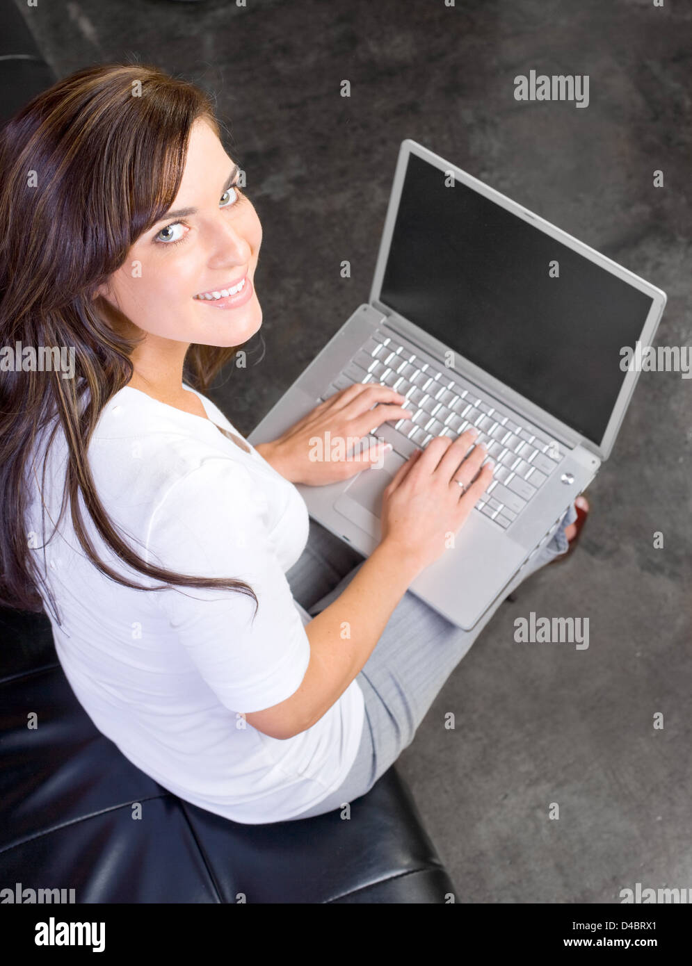 Woman sitting on couch at home useing laptop Stock Photo - Alamy
