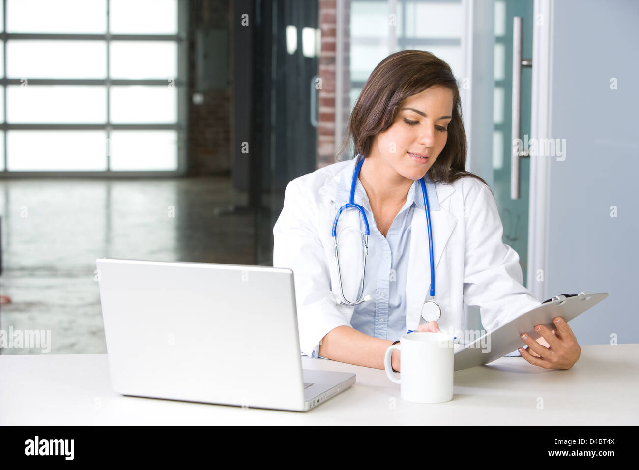 Woman doctor holding a chart in a modern office Stock Photo - Alamy
