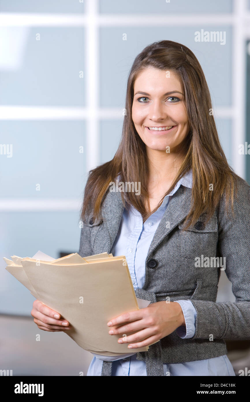 Business woman holding legal documents in modern office Stock Photo - Alamy