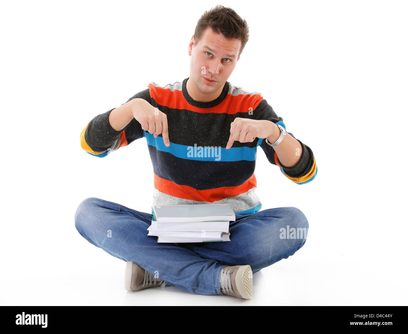 Portrait of a male student sitting offering books isolated on white ...