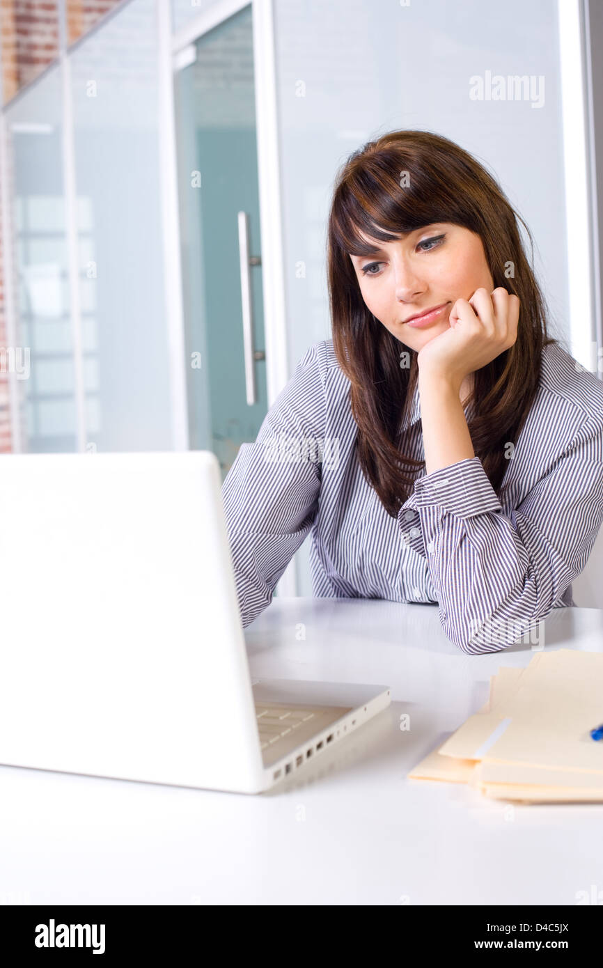 Business woman thinking in modern office with laptop Stock Photo - Alamy