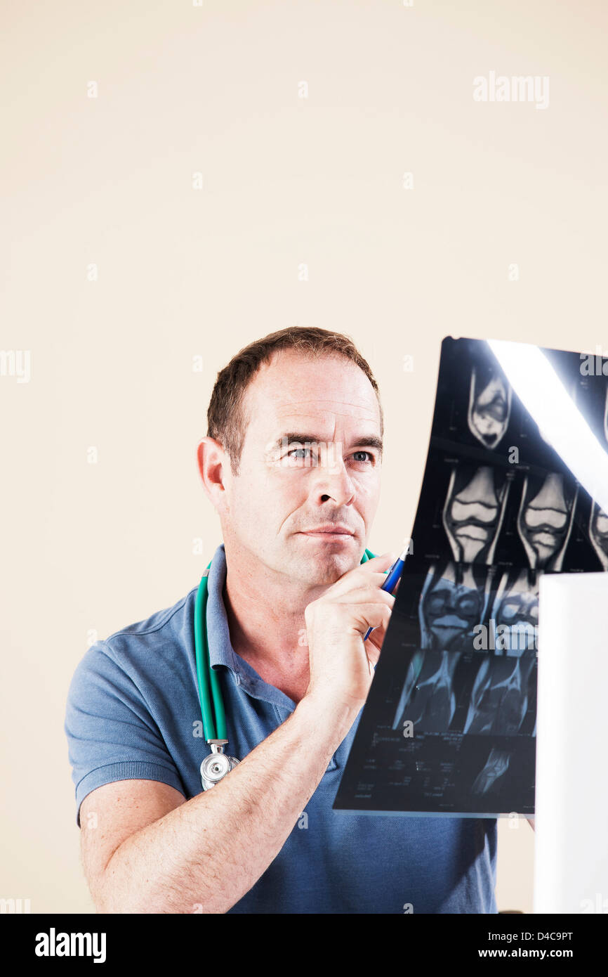 Doctor looking at x-ra photograph Stock Photo - Alamy