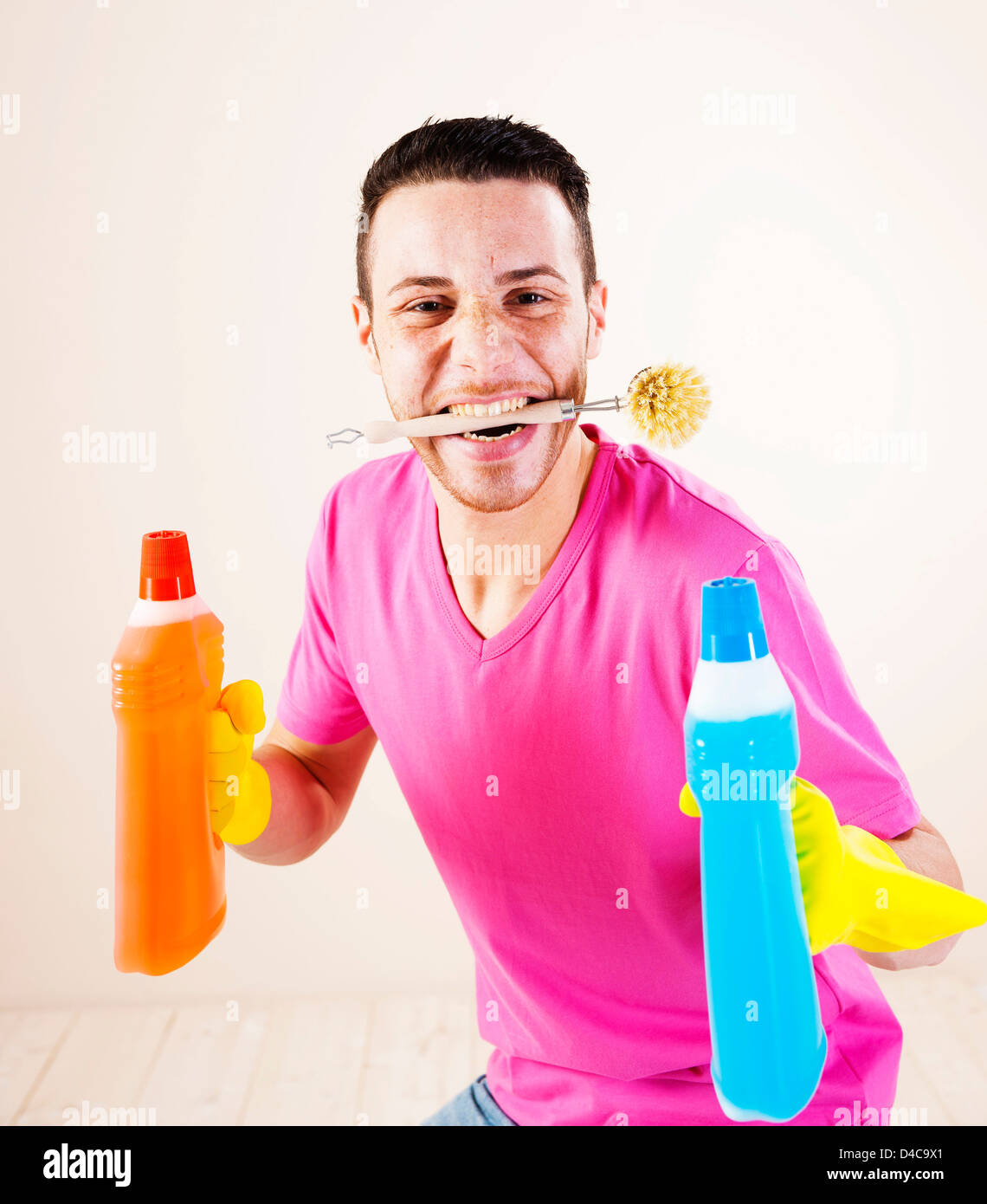 Happy young man holding cleaning agents and brush Stock Photo - Alamy