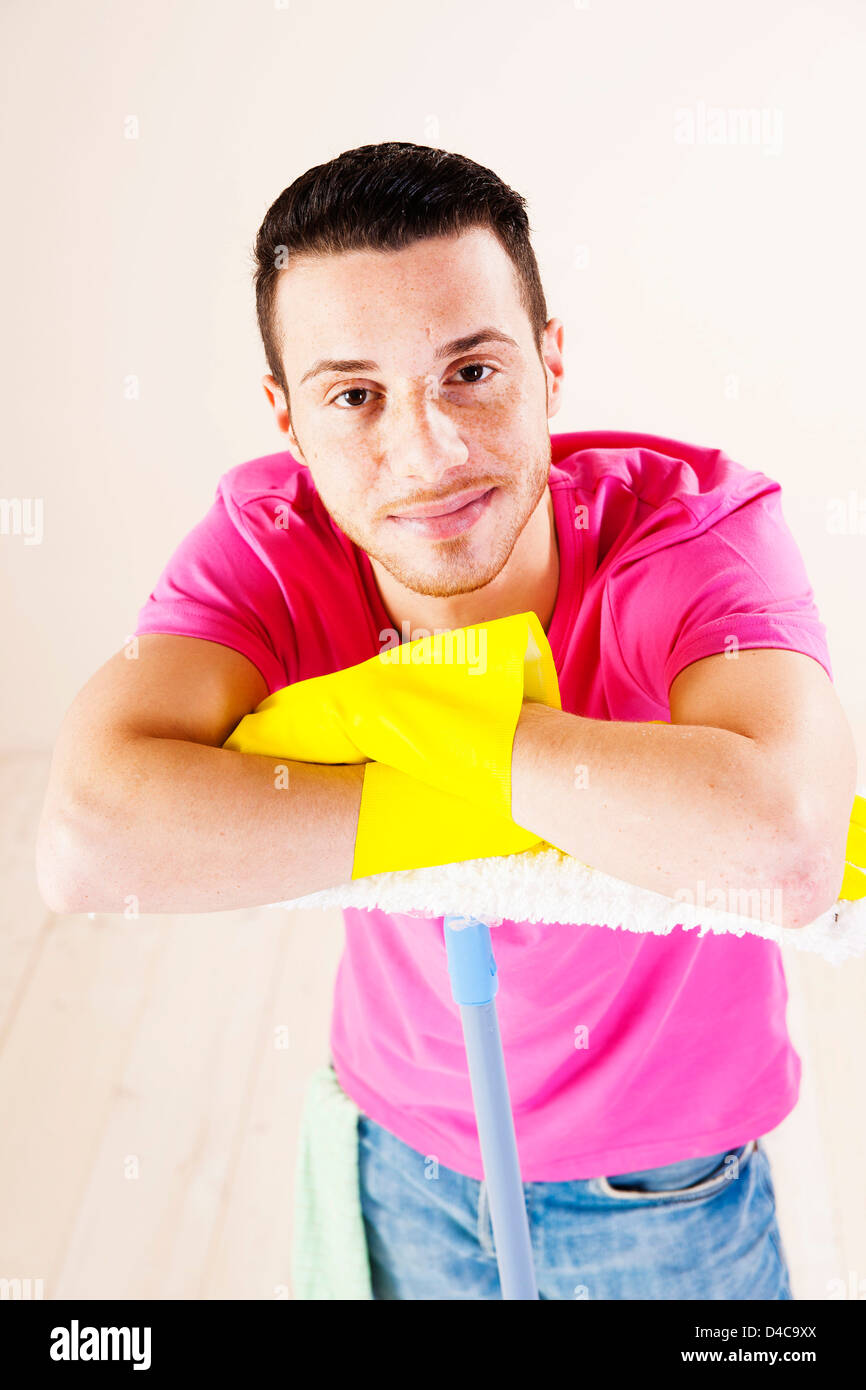 Smiling young man housecleaning Stock Photo - Alamy