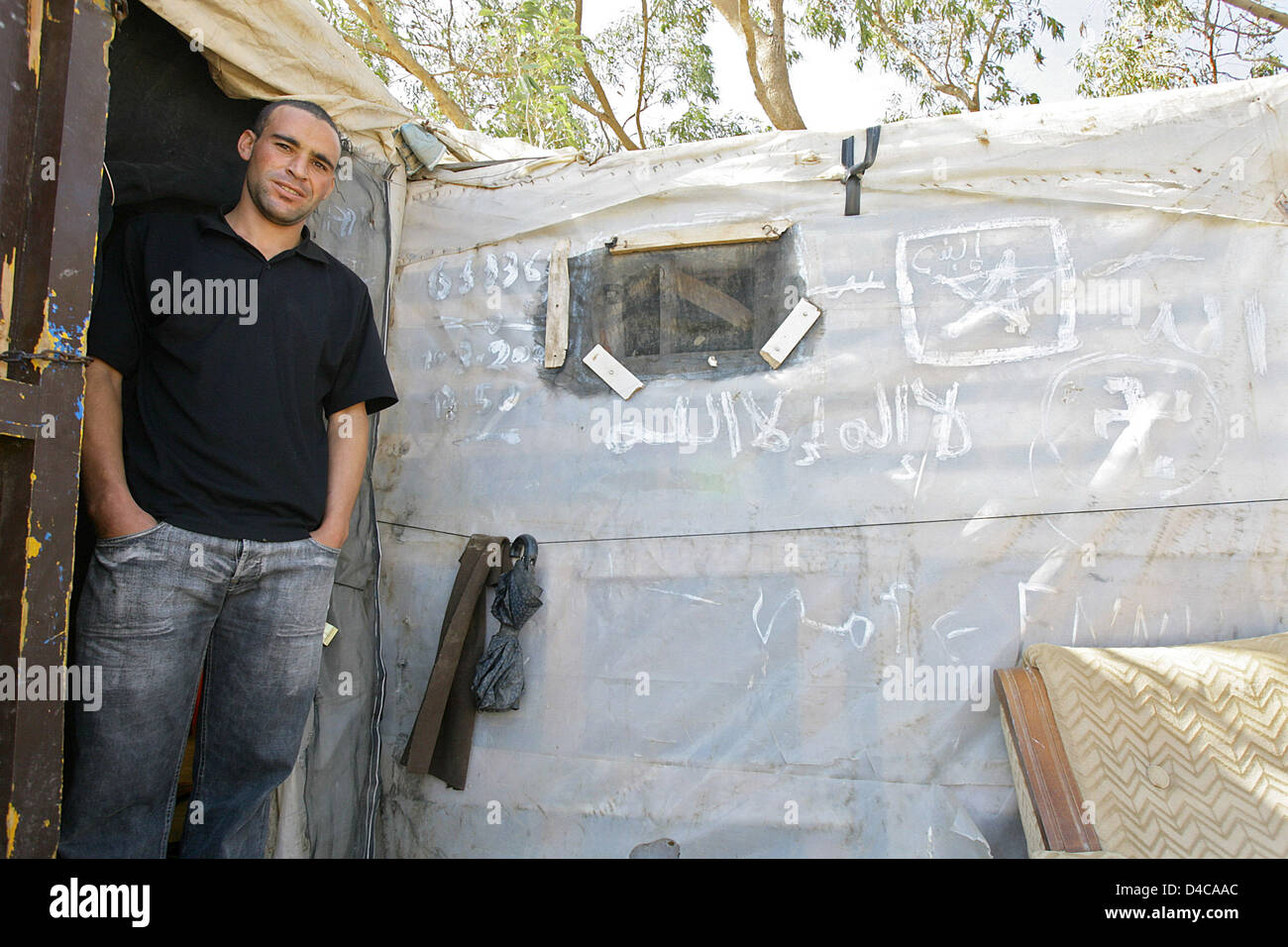 25-year-old El Mostafa from Morocco stands at the entrance to his hut ...