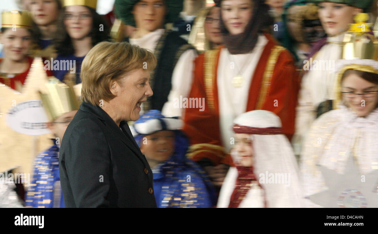 German Chancellor Angela Merkel (C) smiles during the carol singers ...