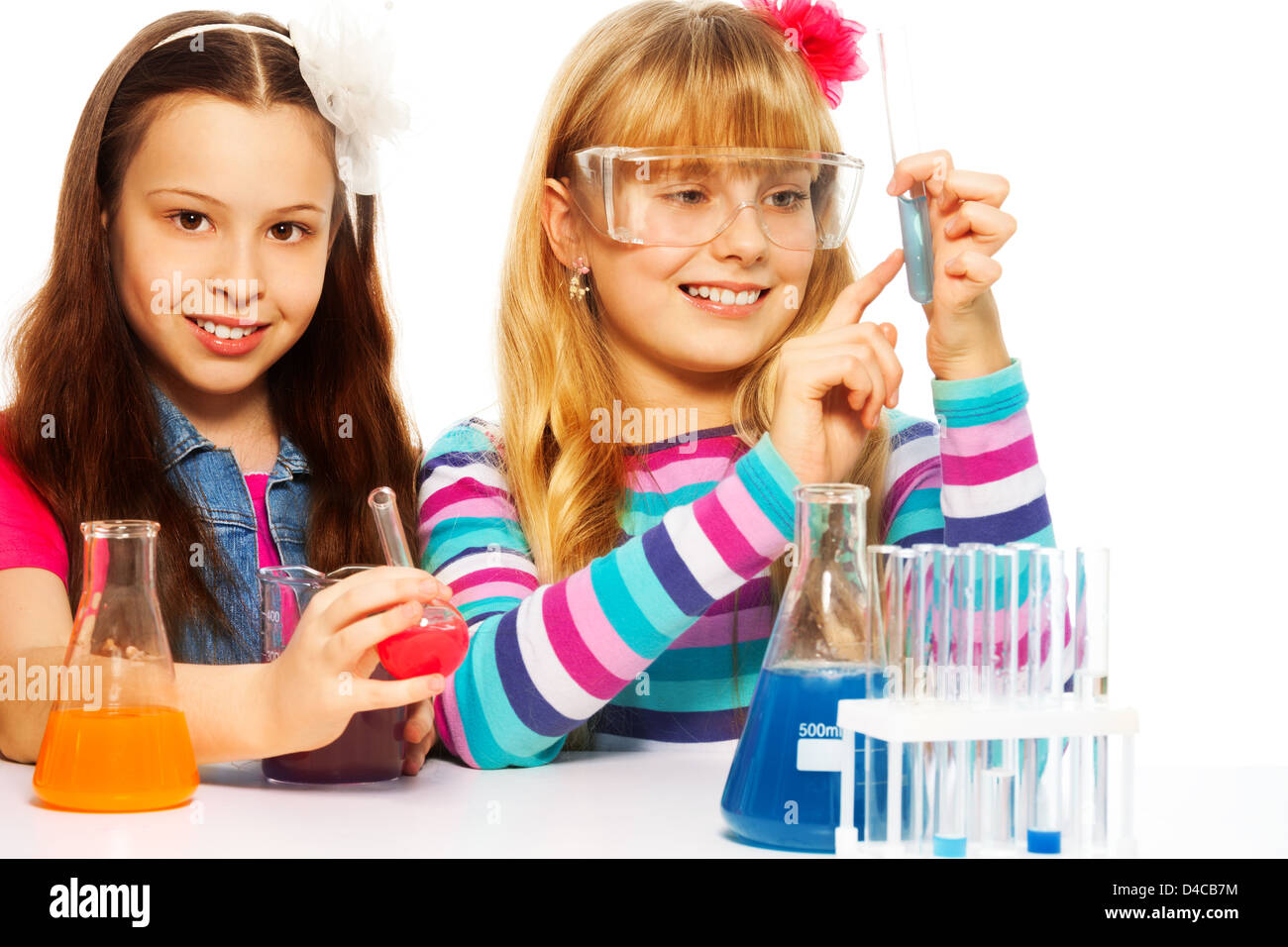 Two girls in chemistry lab class with test tubes and flasks conducting ...