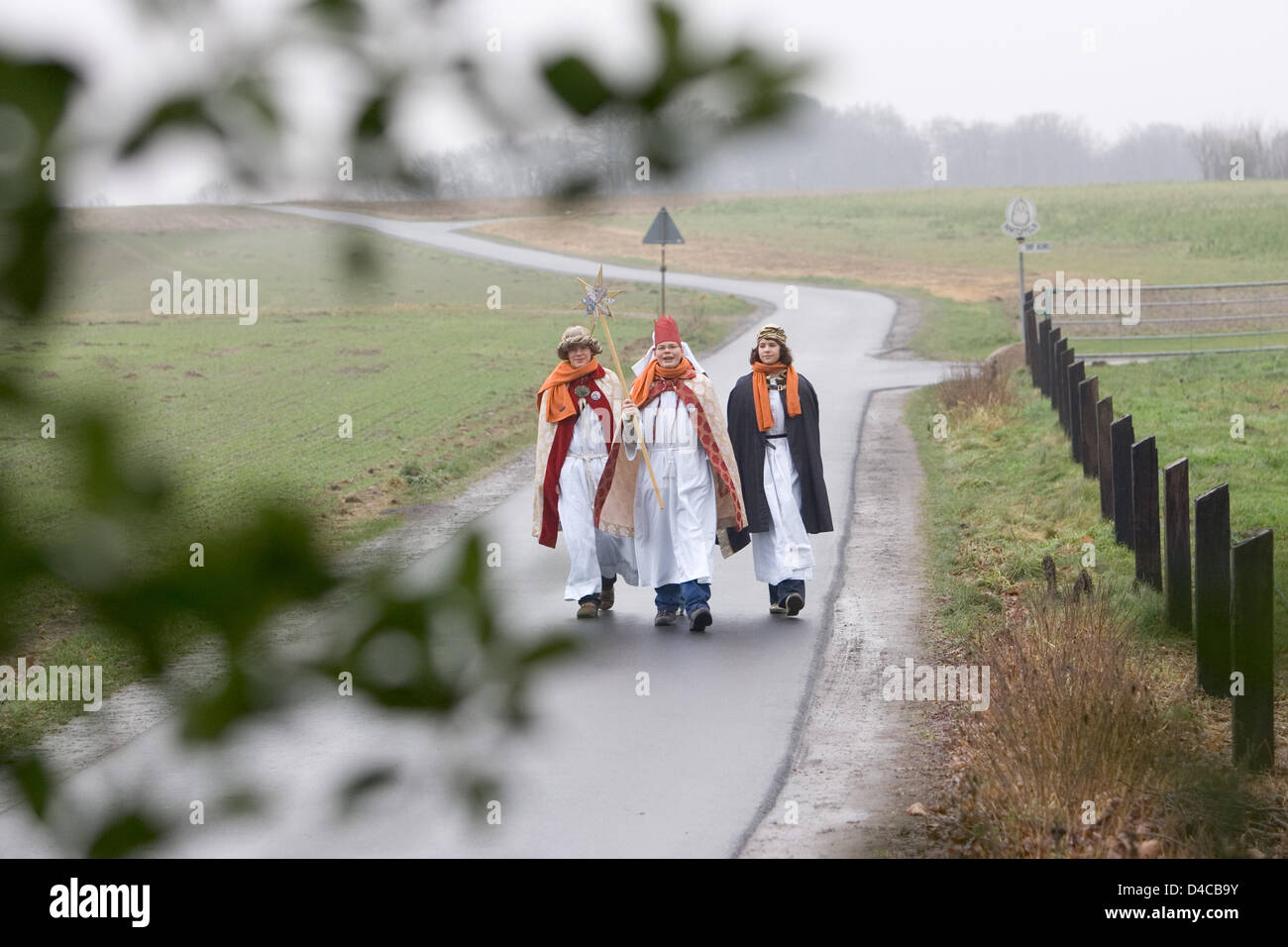 Carollers Nico Lange, Simon Wietke and Luisa Lange (L-R) walks on a ...