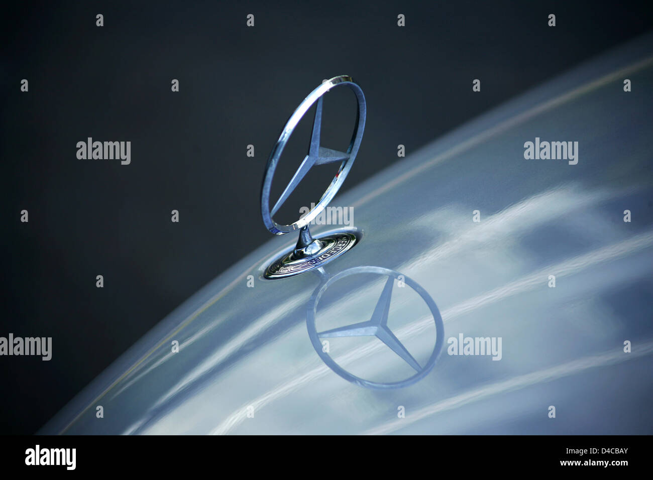 A Mercedes star is reflected in the engine cover in Frankfurt Main ...