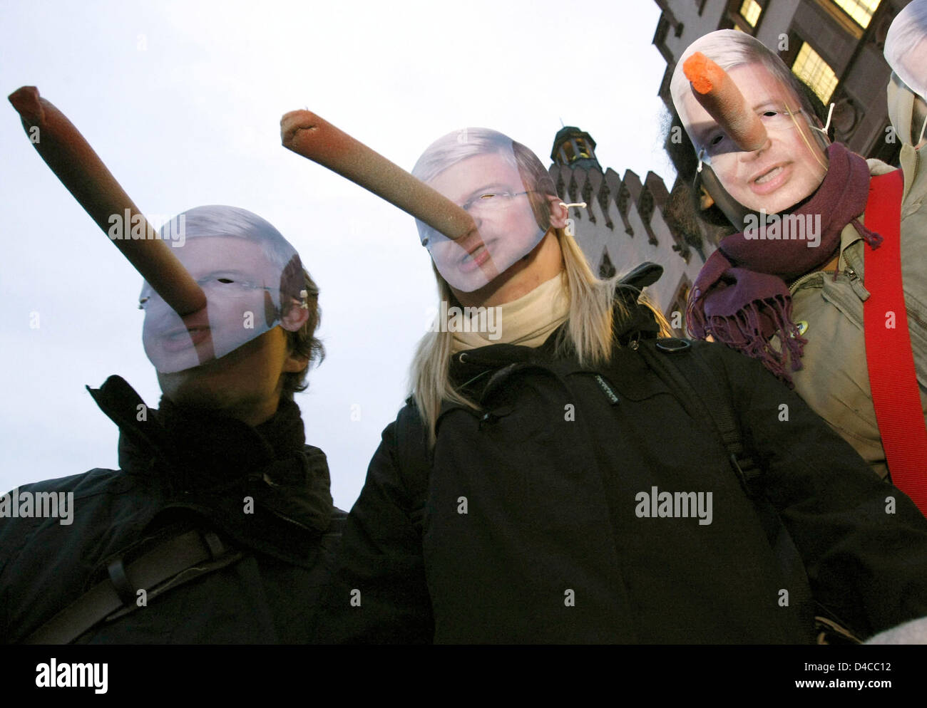 Demonstrators with long-nosed 'pinocchio' masks representing Hesse's ...