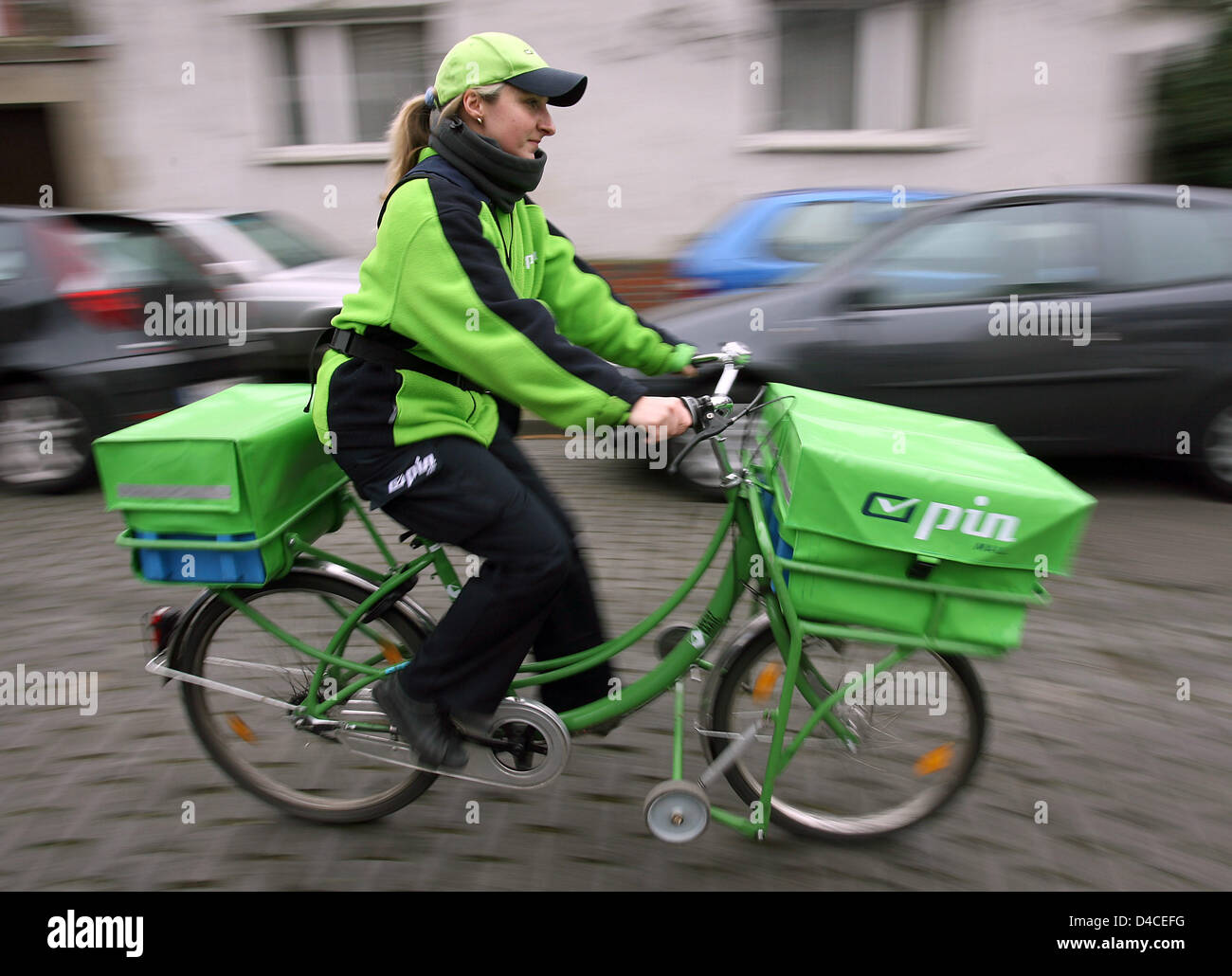 A female mployee of postal service provider PIN drives on her bicycle ...