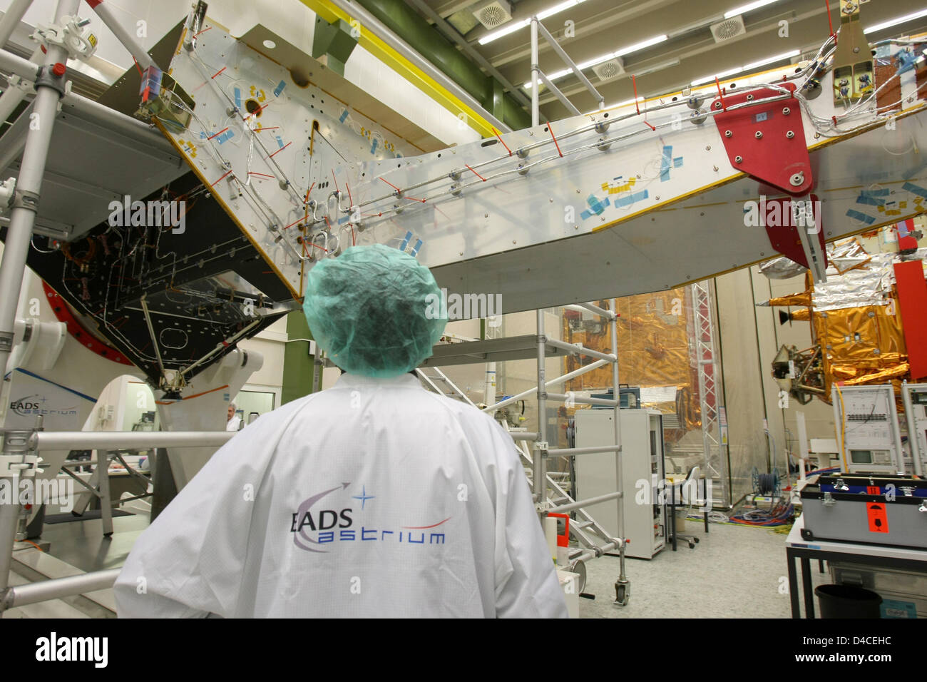 A member of staff stands at a 'CyroSat' satellite in a white room at ...