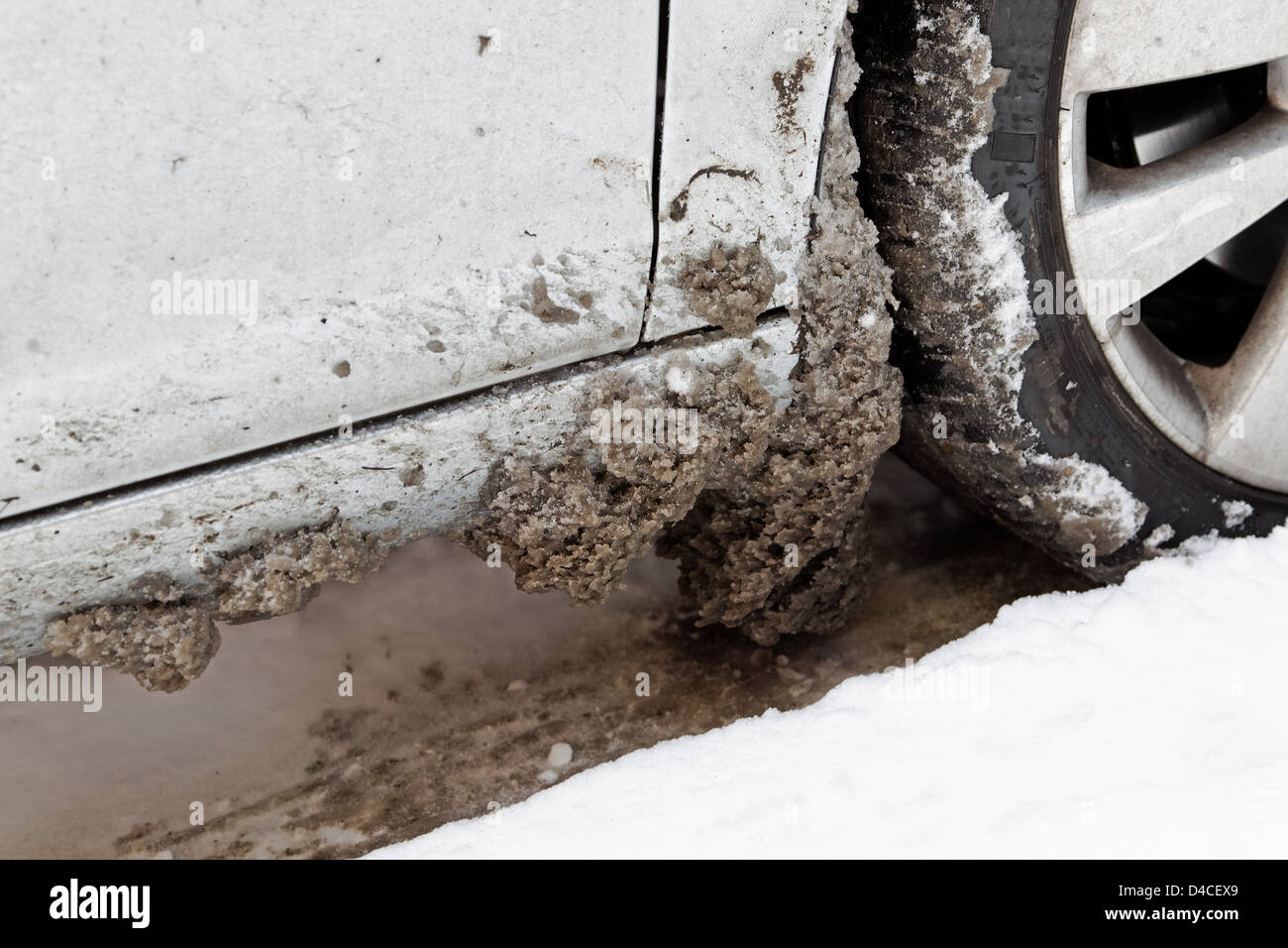 Slush and ice stuck to the underside of a car in winter. Close up with ...