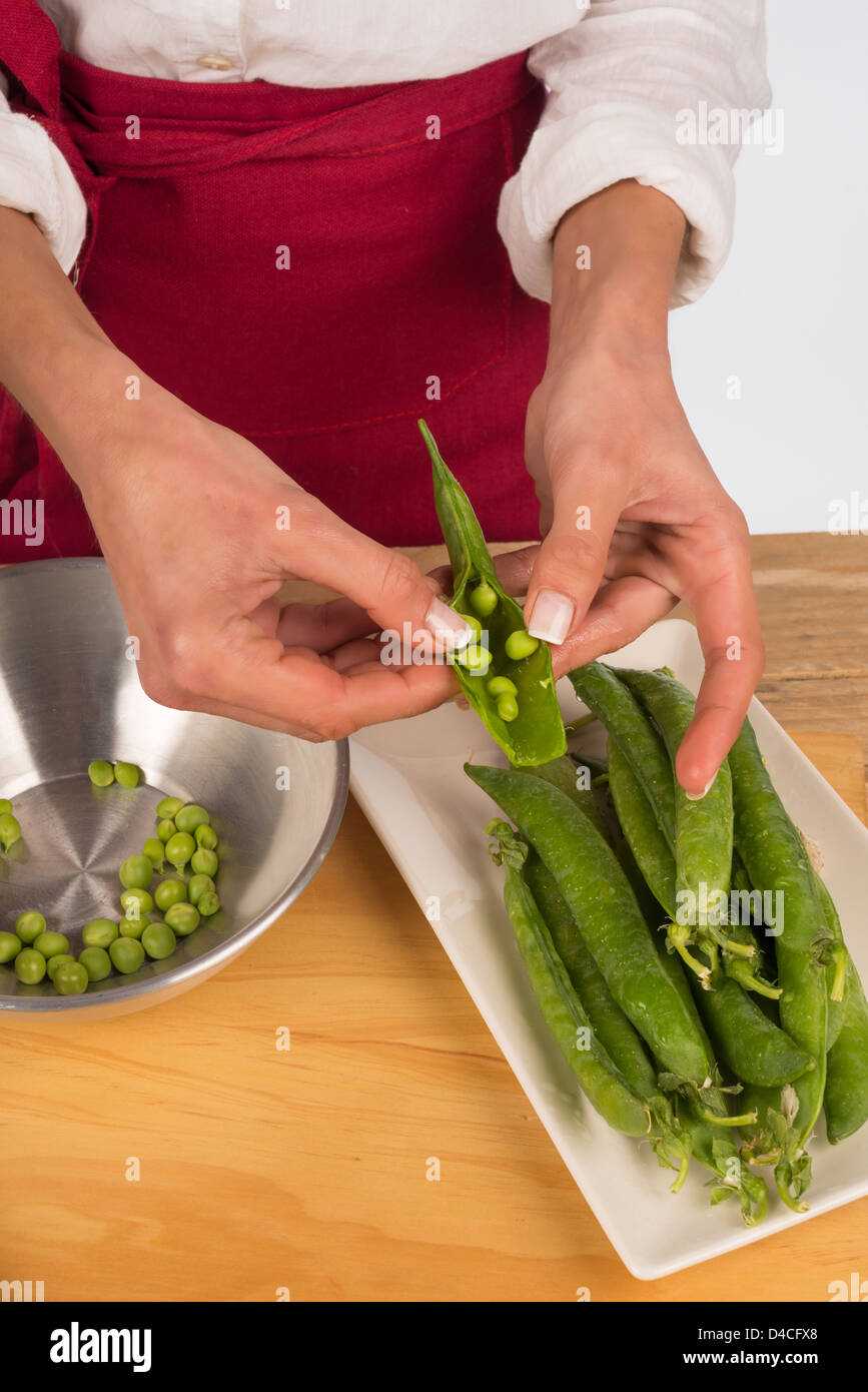 Female hands peeling peas out of their pods Stock Photo - Alamy