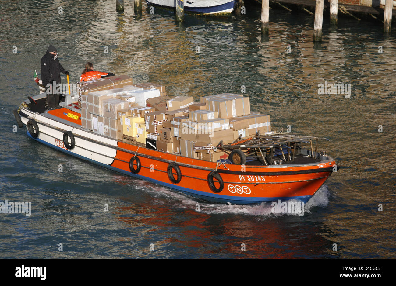 A boat of package service TNT delivers packages at the Grand Canal in ...