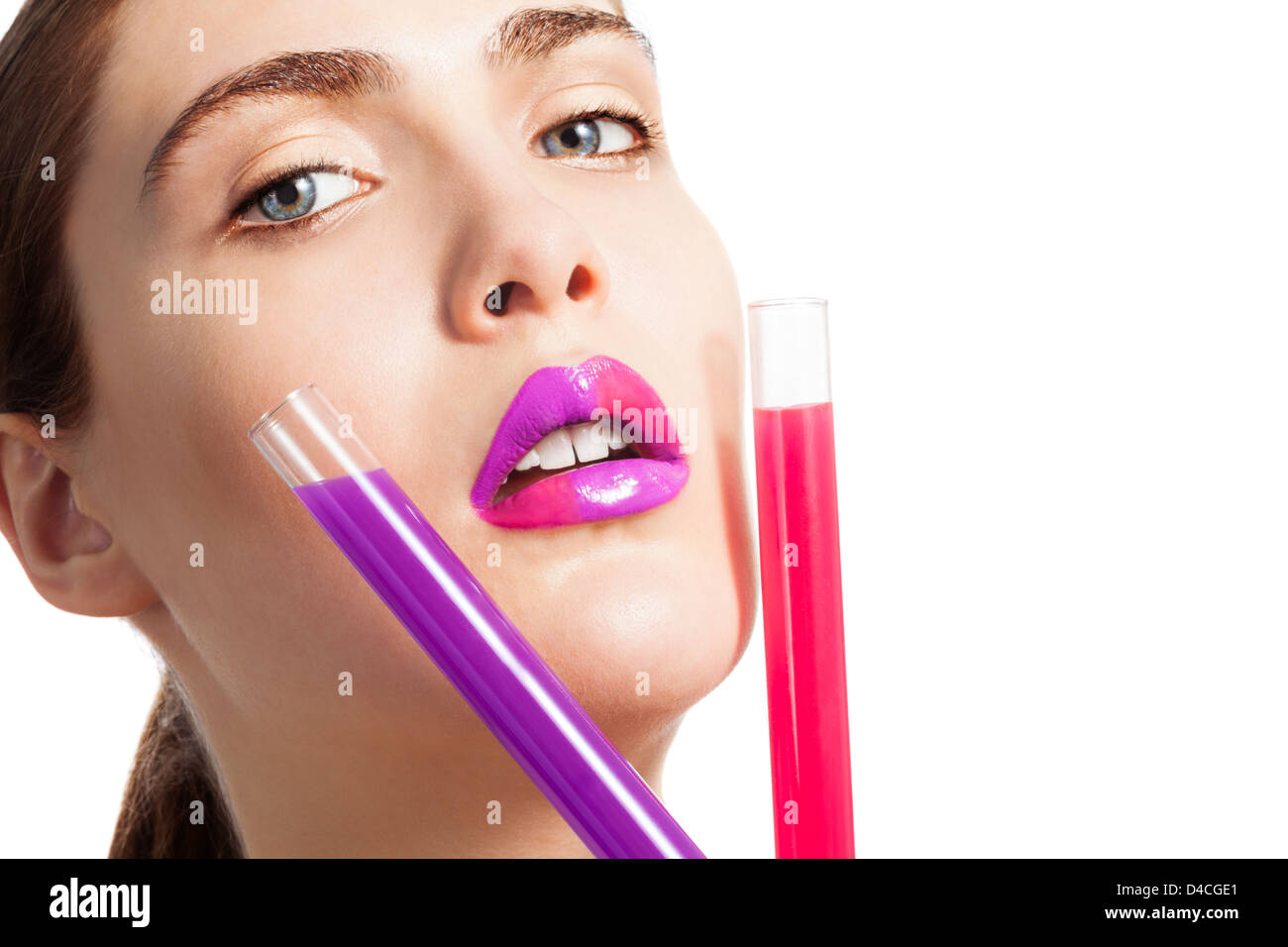 Beautiful woman holding two test tubes with different color liquid as ...